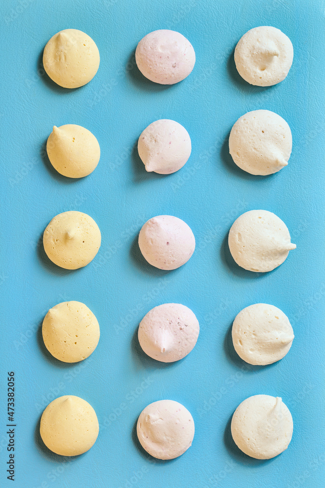 Colored fruit meringues lying in rows on a blue background Stock Photo ...