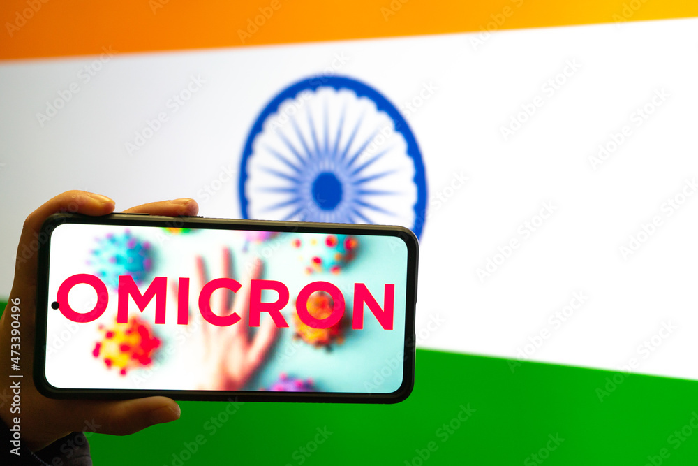 hand holding mobile phone with omicron COVID 19 variant strain in front ...
