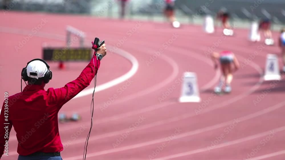Sports judge shoots a starting pistol in an athletics competition ...