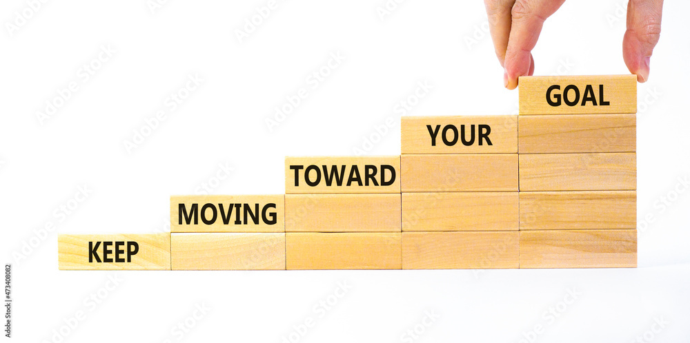 Keep moving toward your goal symbol. Wooden blocks with words Keep moving toward your goal ...