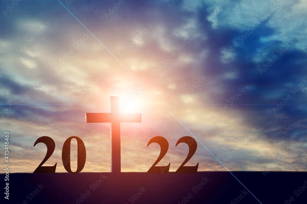 Silhouette of Christian cross with 2022 years at sunset background ...