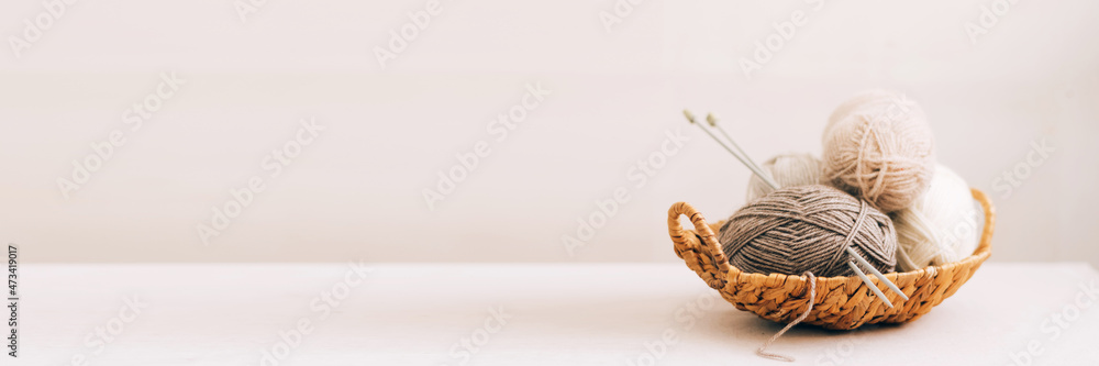 Natural wool in balls of various pastel colors in a wicker basket ...