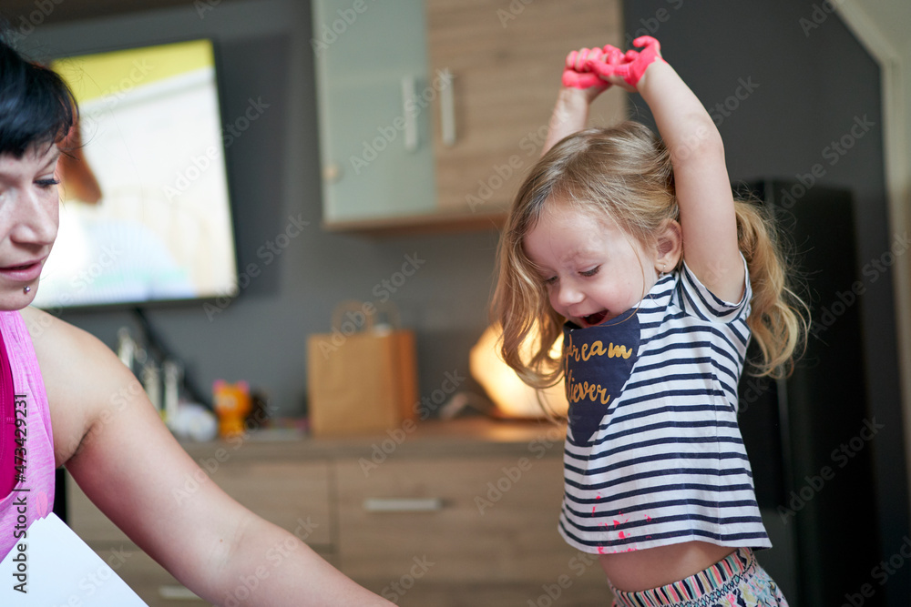 Happy smilling cute little girl with raised hands and painted palms ...