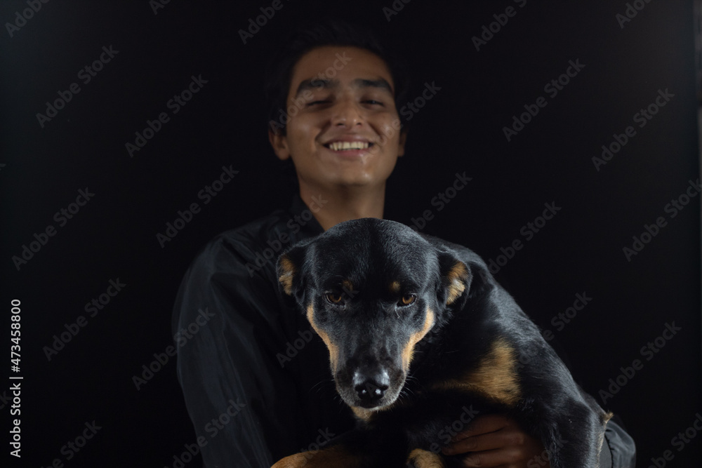 boy carrying his dog, both posing for the picture, the dog has a tender ...