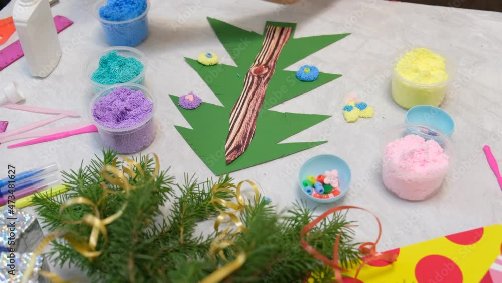 Child makes a greeting card Christmas paper and foam plasticine craft ...