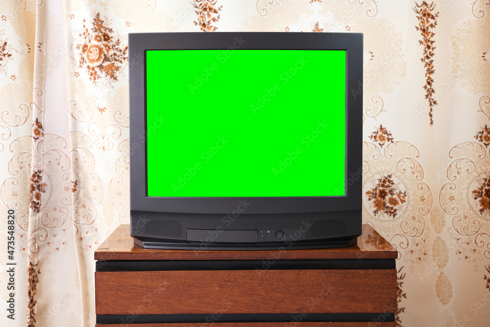 Antique TV with green screen on an antique wooden cabinet, old design ...