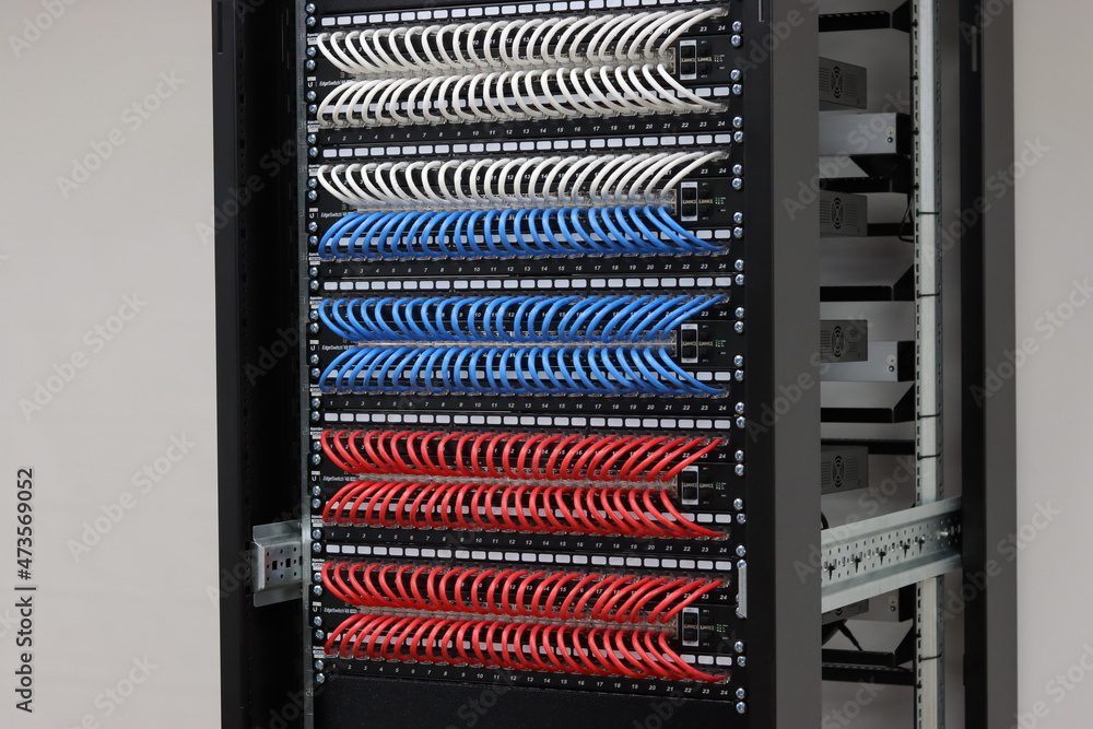 Ethernet switches connected by patch cords to patch panels in the ...