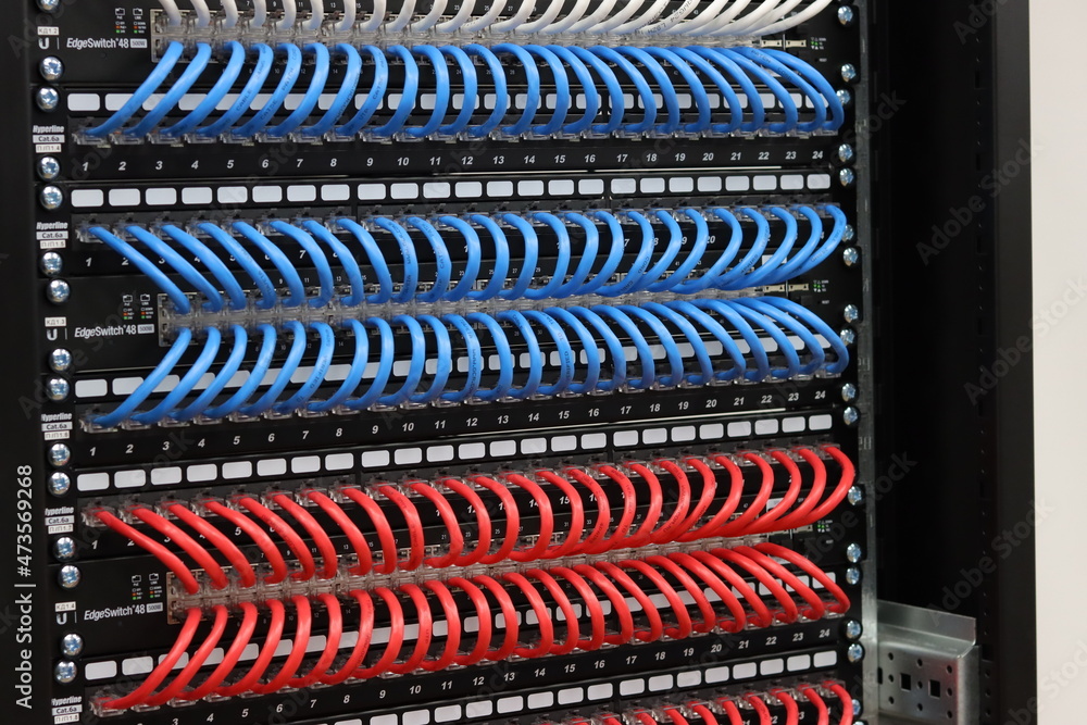 Ethernet switches are connected to patch panels using colored patch ...