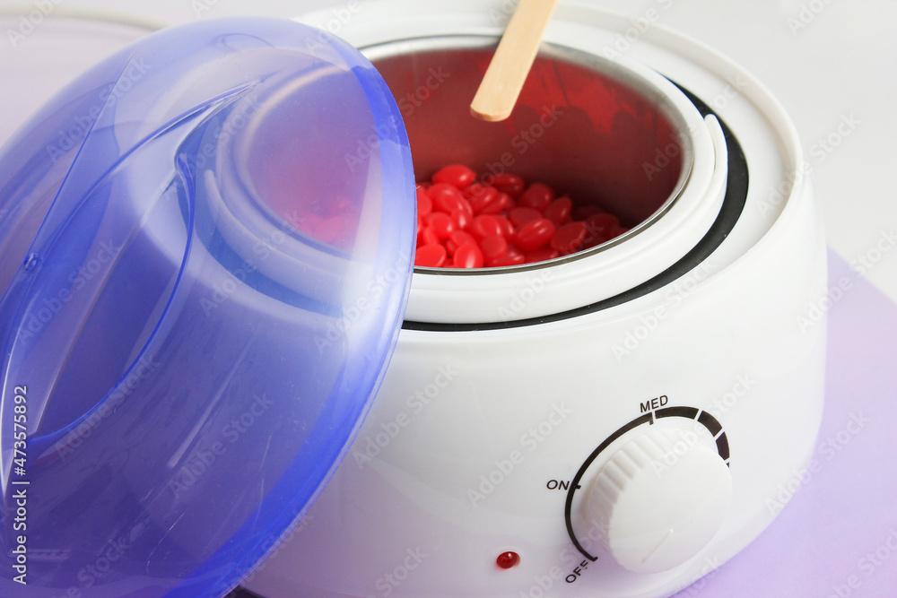 wax for depilation of a red color in the apparatus for heating wax ...