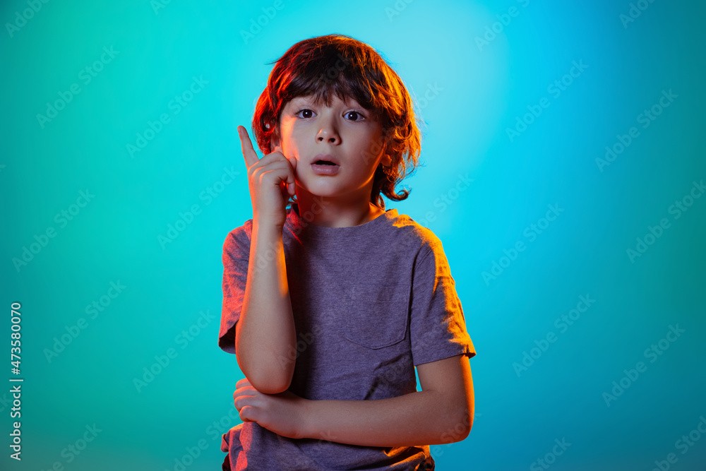 Foto de Half-length portrait of little boy, kid raising finger up ...