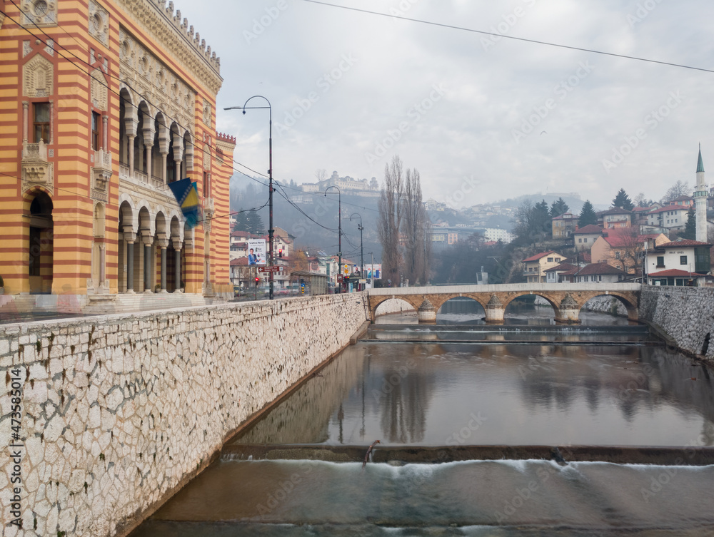 Sarajevo City Hall and the old stone bridge on the Miljacka River in ...