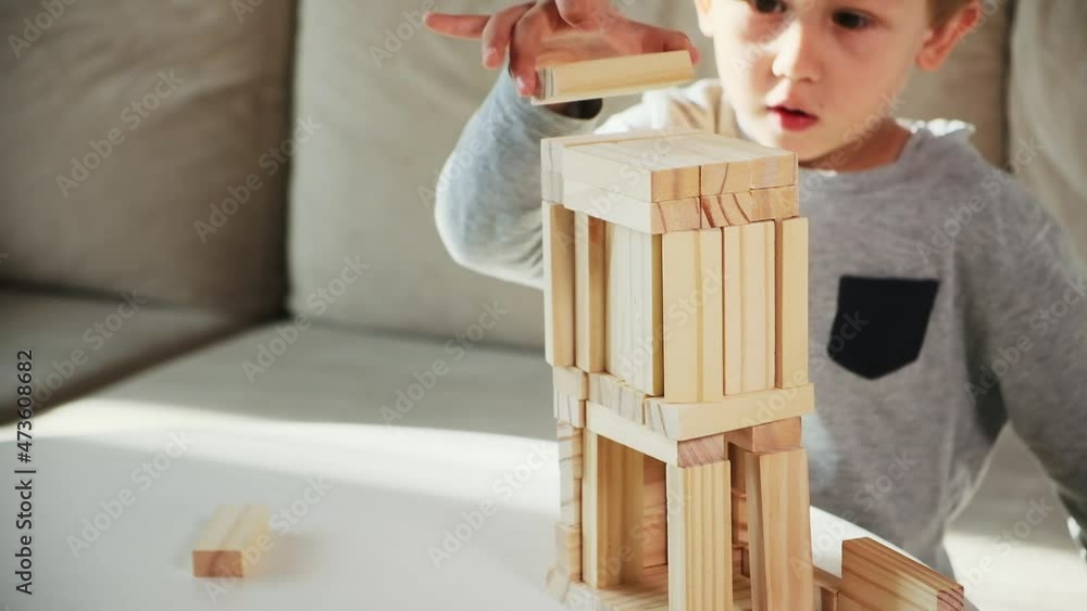 Vidéo Stock Child crash a tower from wooden blocks crying sitting on ...