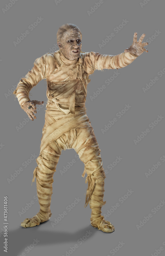 Full length portrait of a man dressed as a mummy wrapped in decaying ...