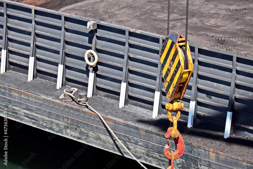 Loading coal from cargo barges onto a bulk carrier using ship cranes ...