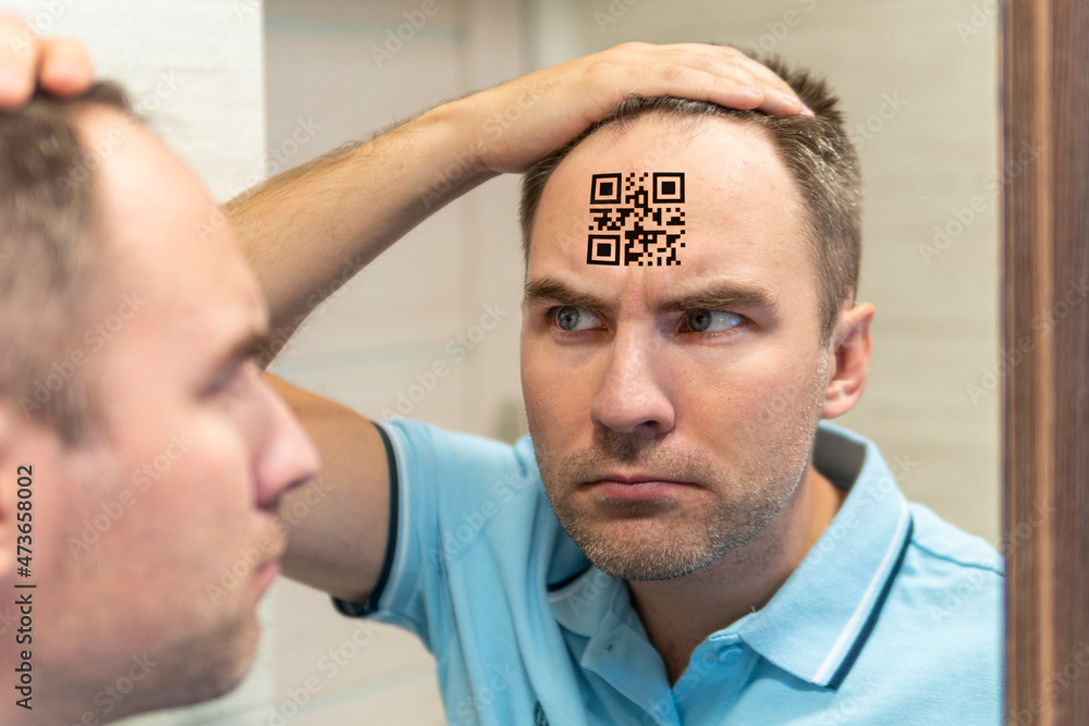 Foto de young man with a qr code on his forehead. A man with a stupid ...