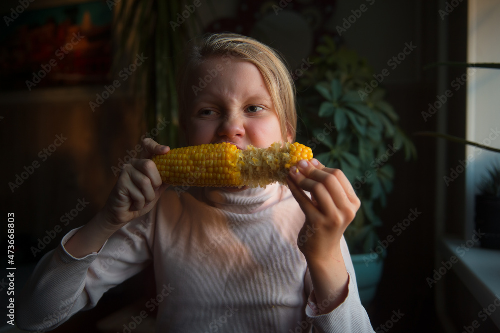 girl eating corn at home Stock Photo | Adobe Stock