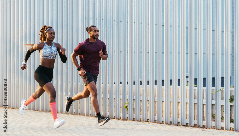 Active black couple running on pavement Stock Photo | Adobe Stock