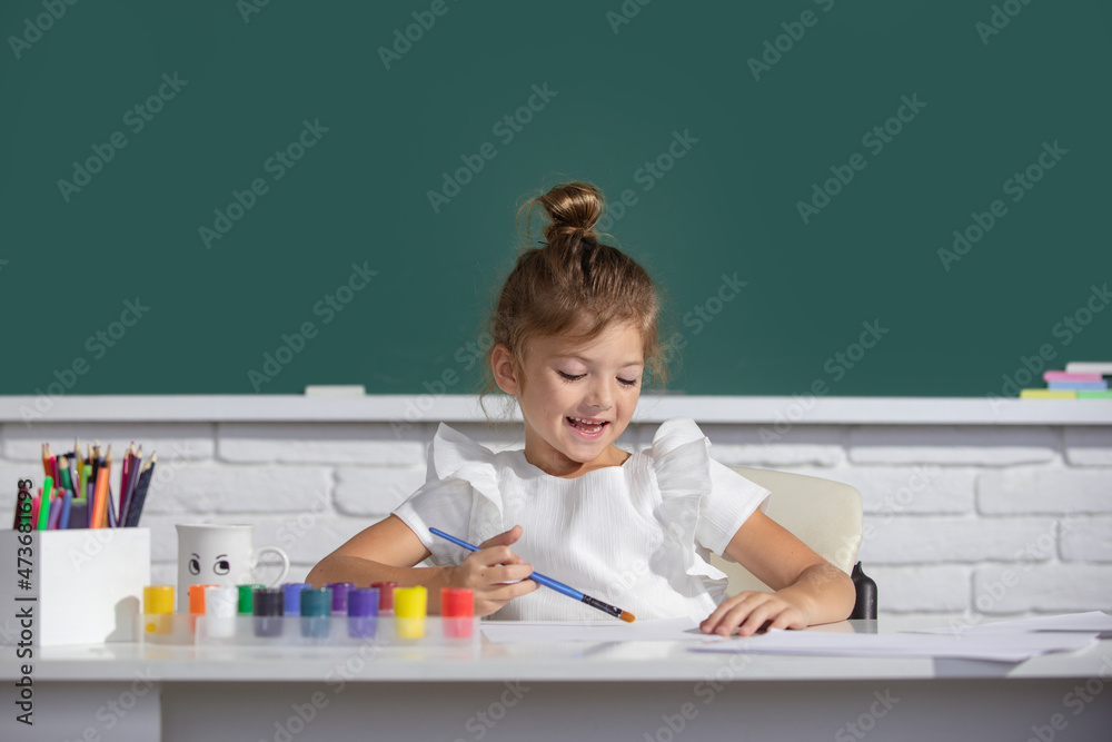 Little girls drawing a colorful pictures with pencil crayons in school ...
