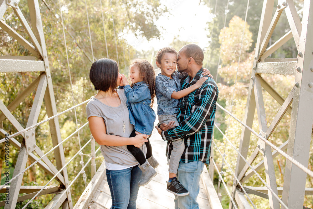 Parents and mixed race kids on pedestrian bridge Stock Photo | Adobe Stock