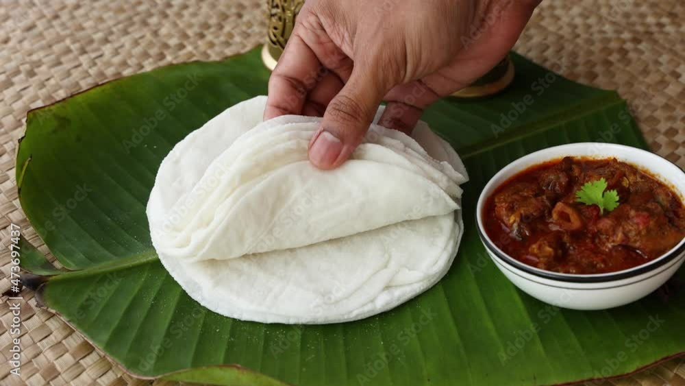 Rice Pathiri pathir flat bread spicy chicken curry woman hand serving ...