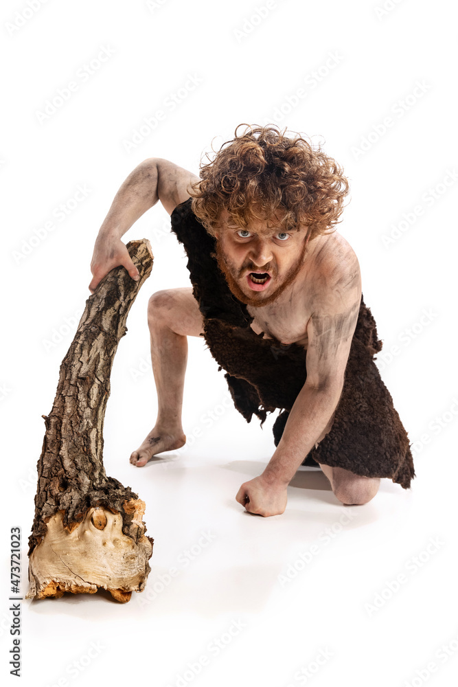 Full-length portrait of man in character of neanderthal climbing with ...