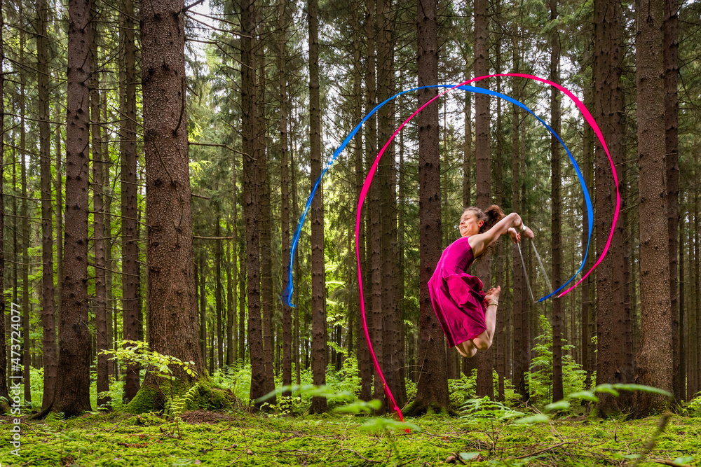 Young female gymnast practicing gymnastics with ribbons in forest Stock ...