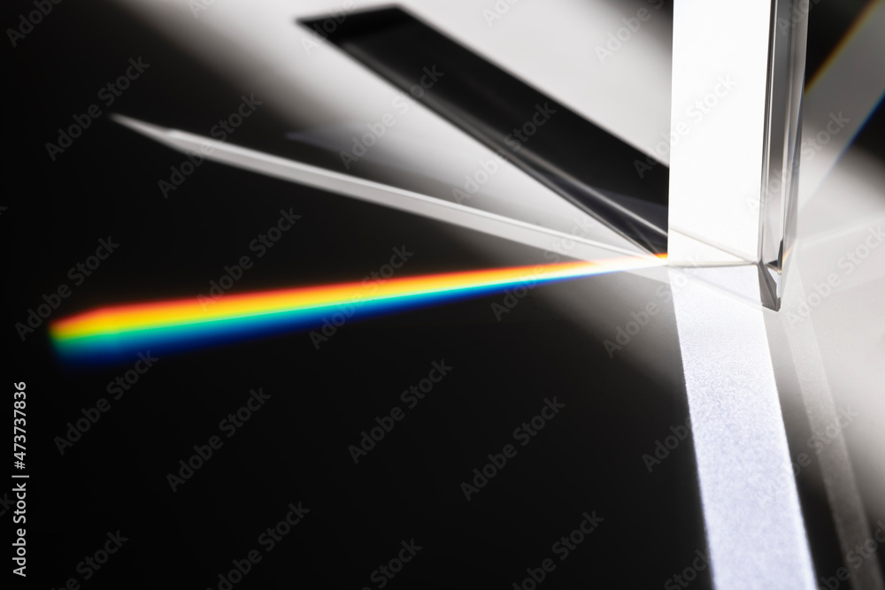 Triangular Prism dispersing sun beam splitting into a spectrum on white ...