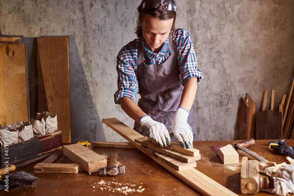 Business woman working as carpenter in a small carpentry workshop ...