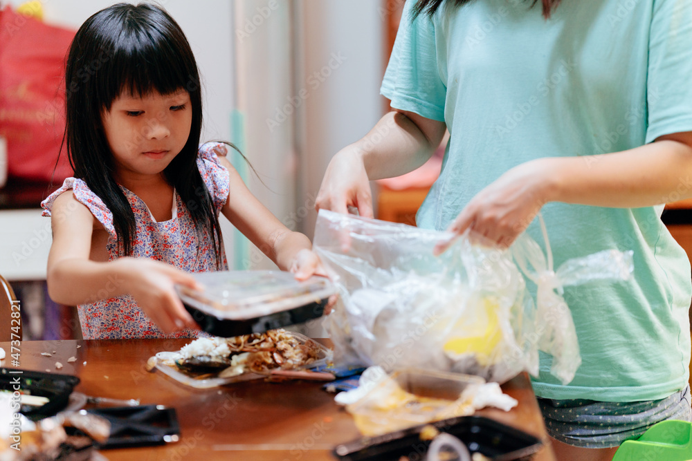 Little girl clean up dining table garbage Stock Photo | Adobe Stock