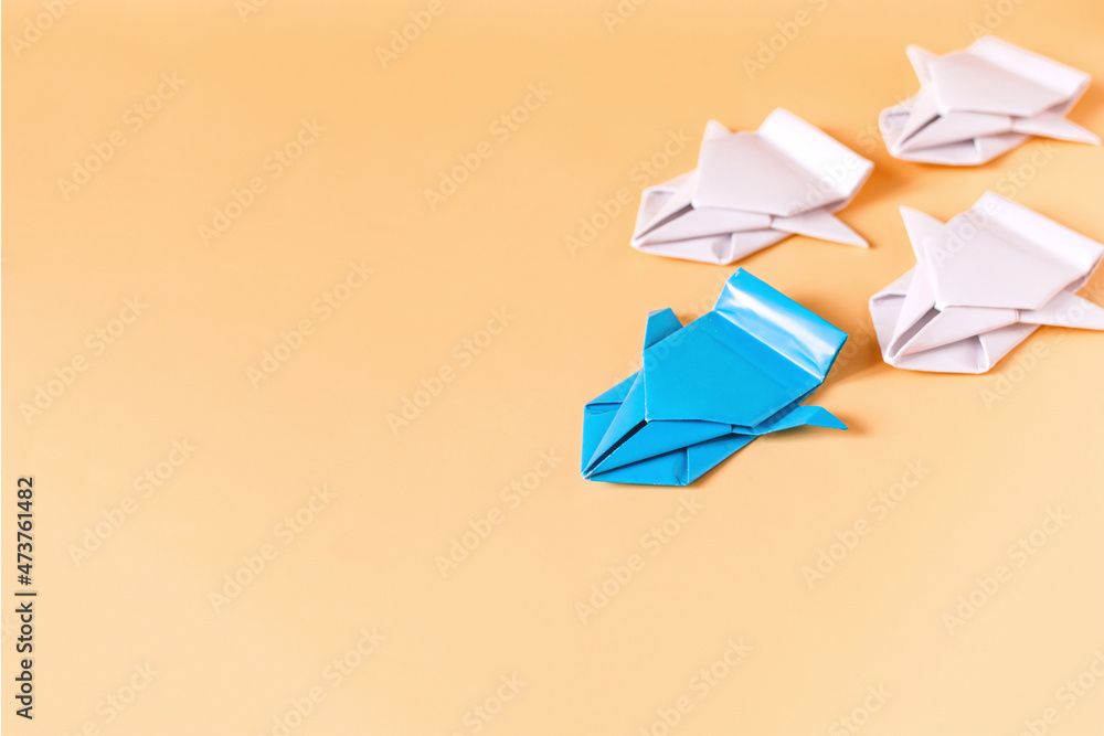 The concept of competition. Origami machine made of colored paper ahead ...