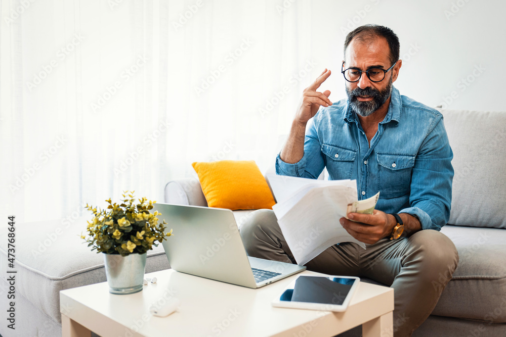 Confused frustrated mature man holding mail letter and money, reading ...