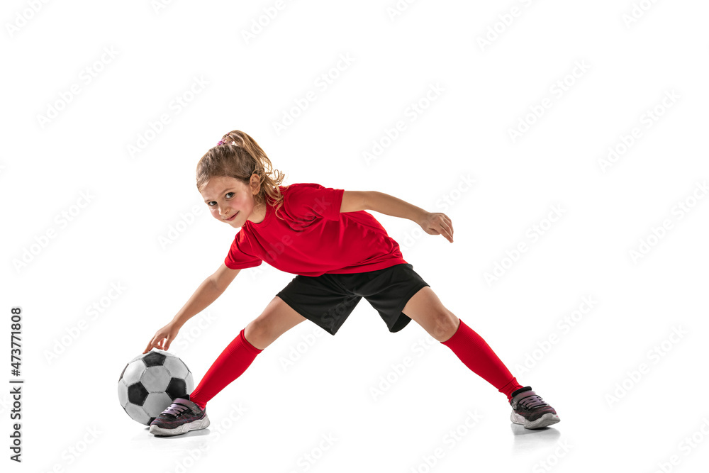 Full-length portrait of little cheerful girl playing football in red ...