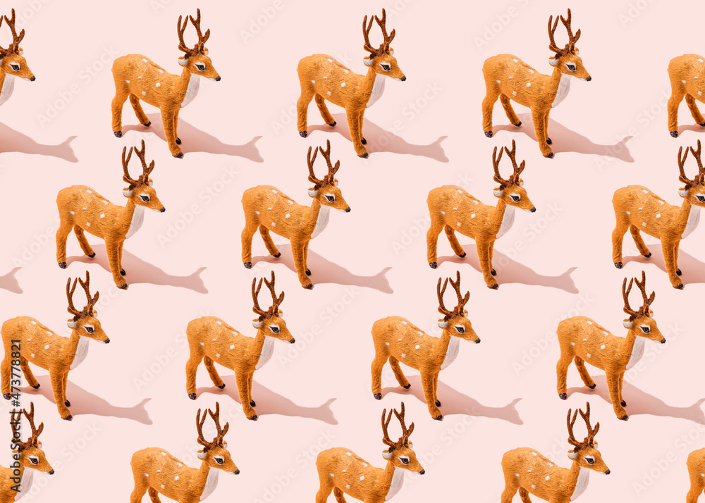 Pattern of reindeer figurines standing against pink background Stock ...