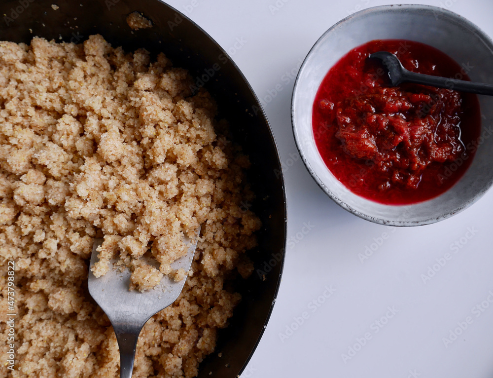 Austrian crumble dessert in cast iron pan served with homemade plum ...
