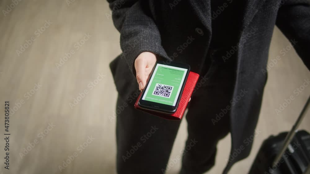 Tourist showing QR code on phone in airport terminal. Vaccination ...