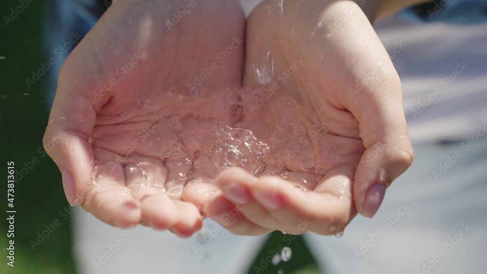 water bubbles in human hand drip and splash in different directions ...