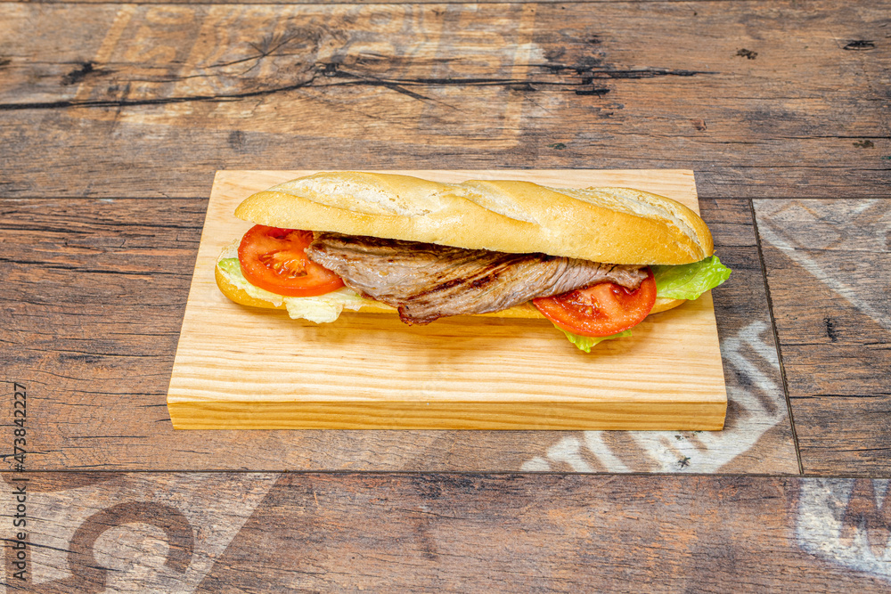 Beef sirloin pepito with peppers and melted cheese with tomato and ...