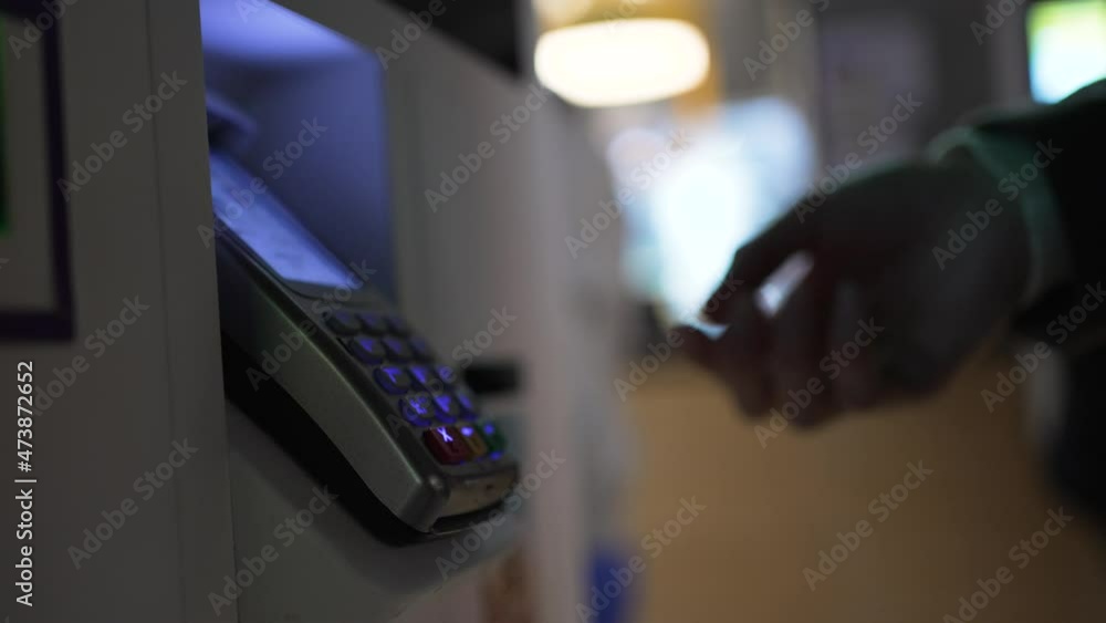 Young man worker silhouette in grey suit pays with pay pass using phone ...