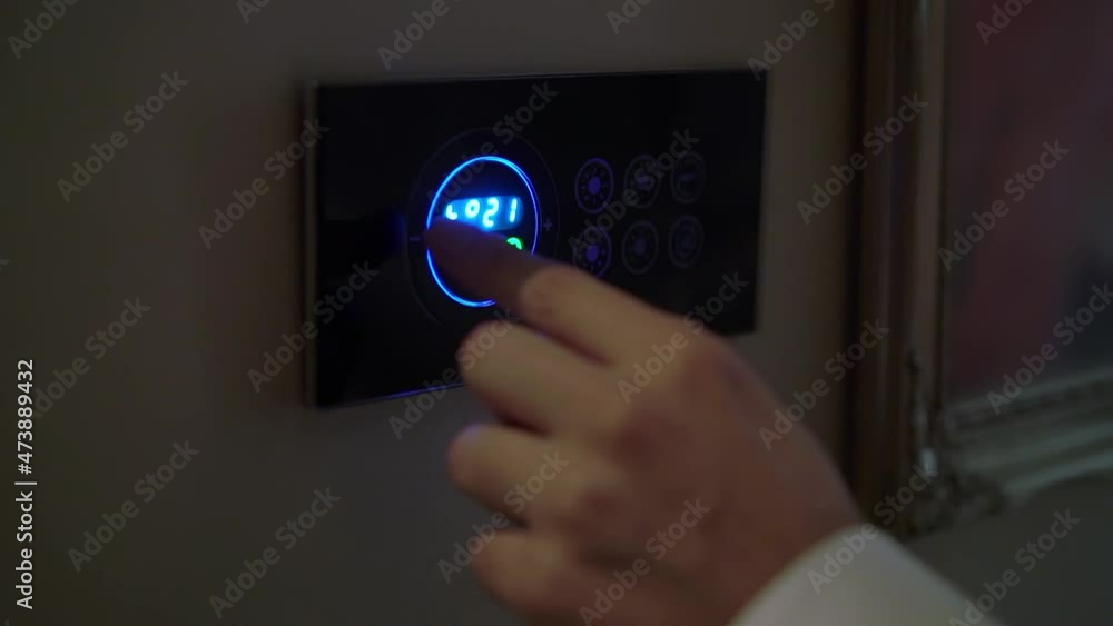 Air conditioning control panel. The man operates the touch buttons on ...