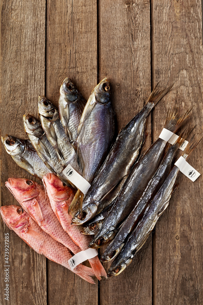 Dried salted roach, sabrefish and red mullets with labels on tails on ...
