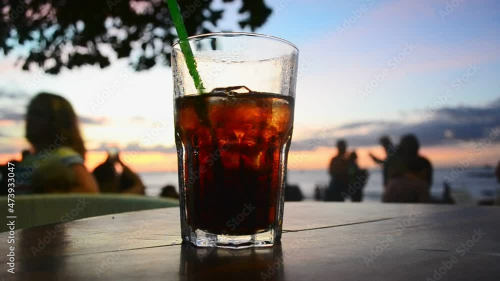 Ice cold cola drink at the beach in Tamarindo, Costa Rica during sunset ...