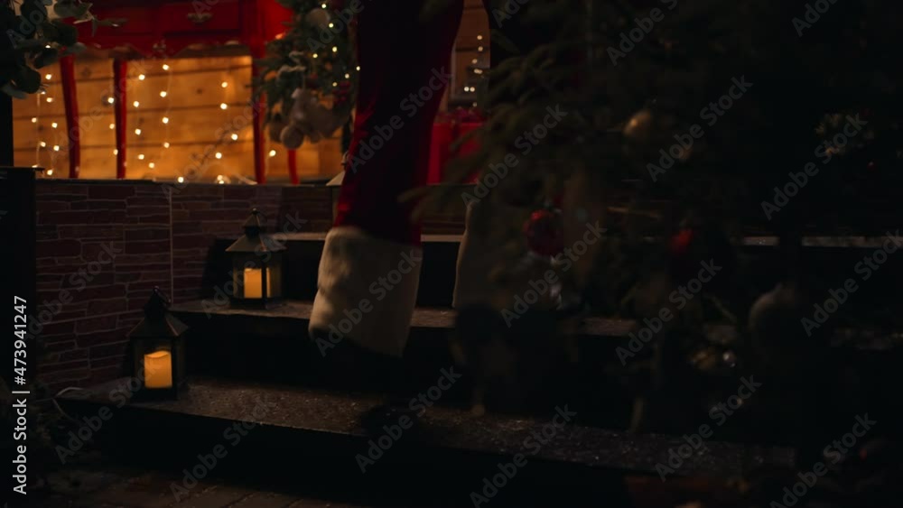Close-up of Santa Claus's feet walking down the steps of the house on ...