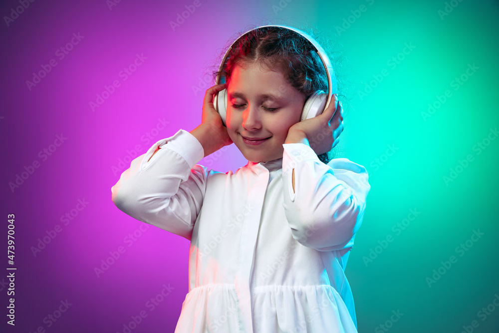 Half-length portrait of calm little girl, kid listening audio fairy ...