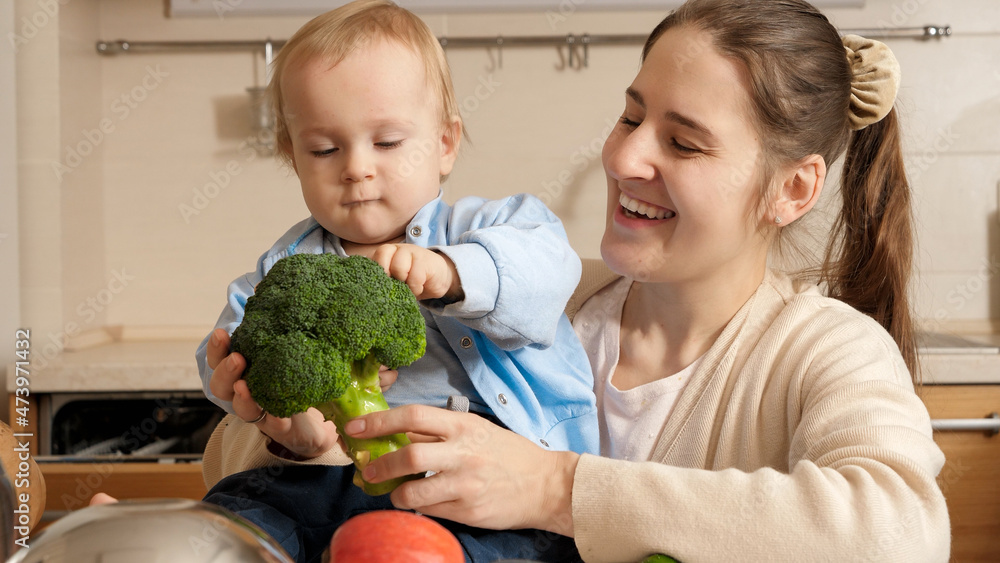 Cute baby boy exploring kitchen utensils, fruits and vegetables on ...