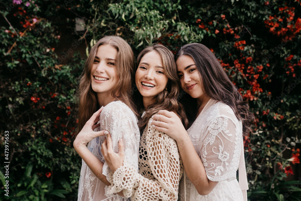 Smiling young women standing together by plants Stock Photo | Adobe Stock