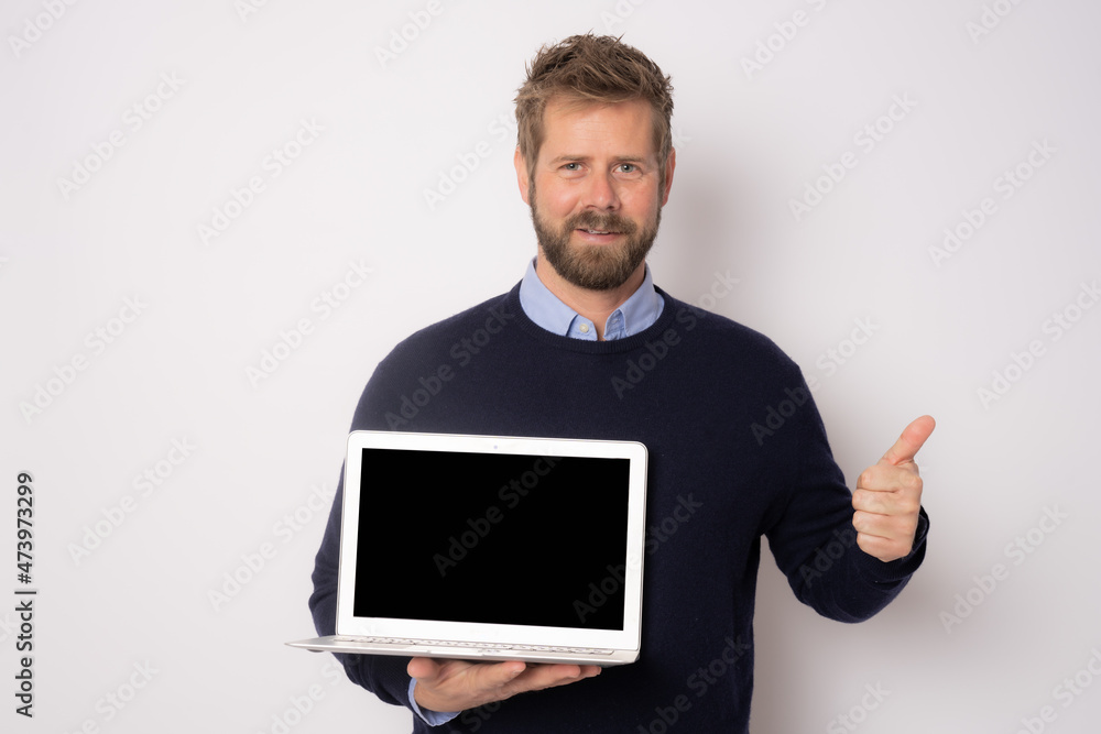 Young smiling handsome man showing laptop computer screen with thumb up ...