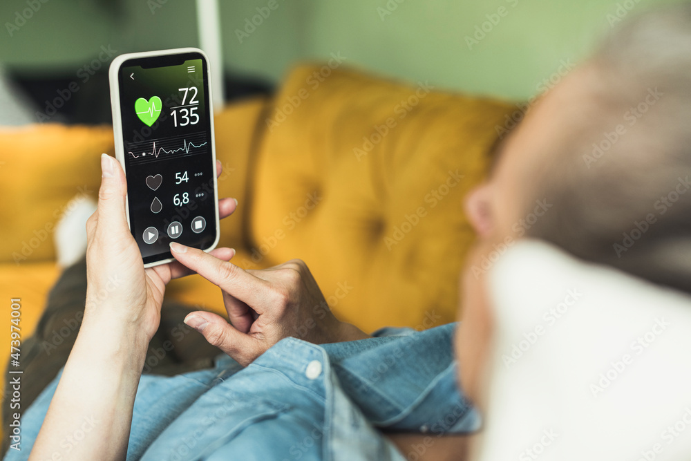 Woman checking health record through smart phone at home Stock Photo ...