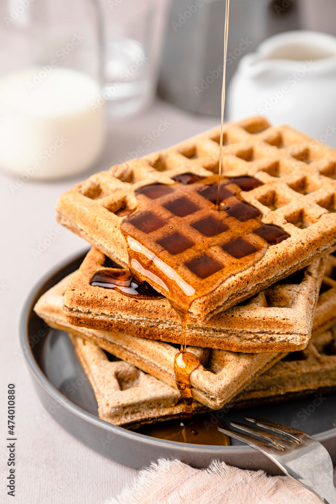 Maple syrup pouring on stack of fresh waffles Stock Photo | Adobe Stock