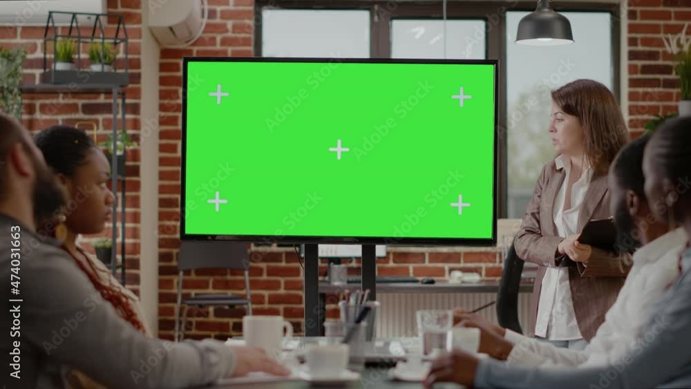 Diverse business people looking at green screen on monitor display ...