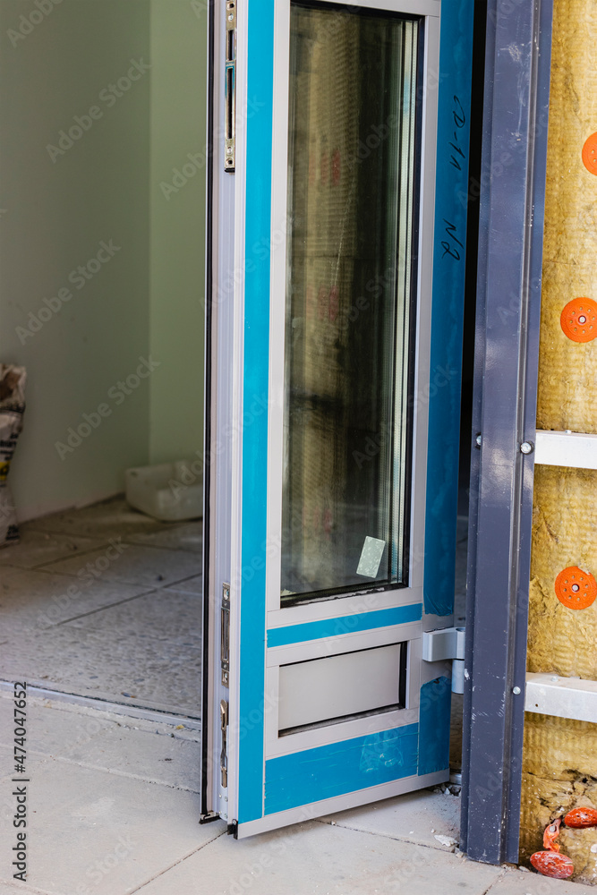 Installation of a glass entrance door in a building under construction ...